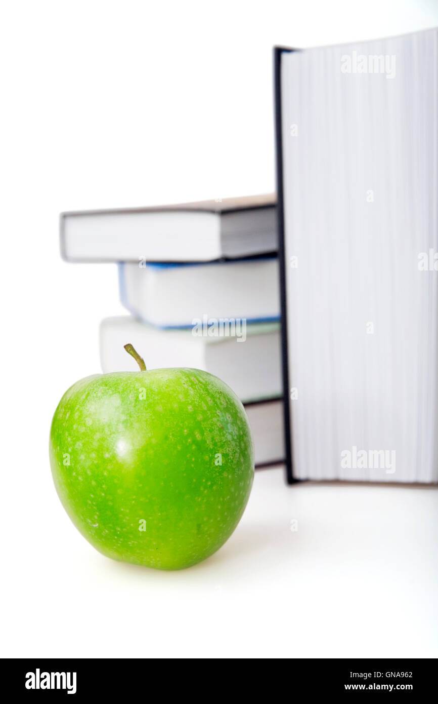 Bright green apple and books Stock Photo - Alamy