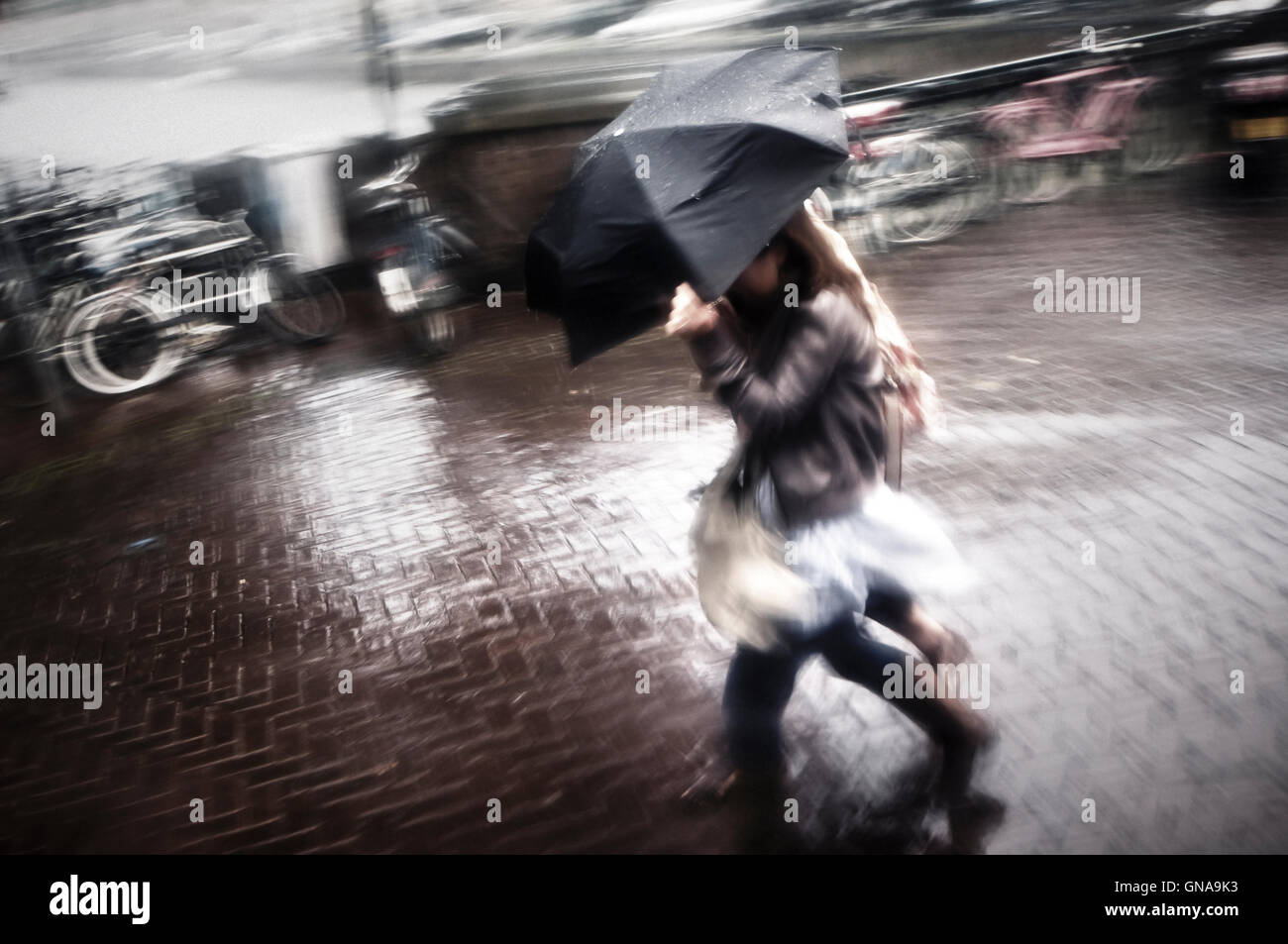 Two women under umbrella in rain and wind Stock Photo - Alamy