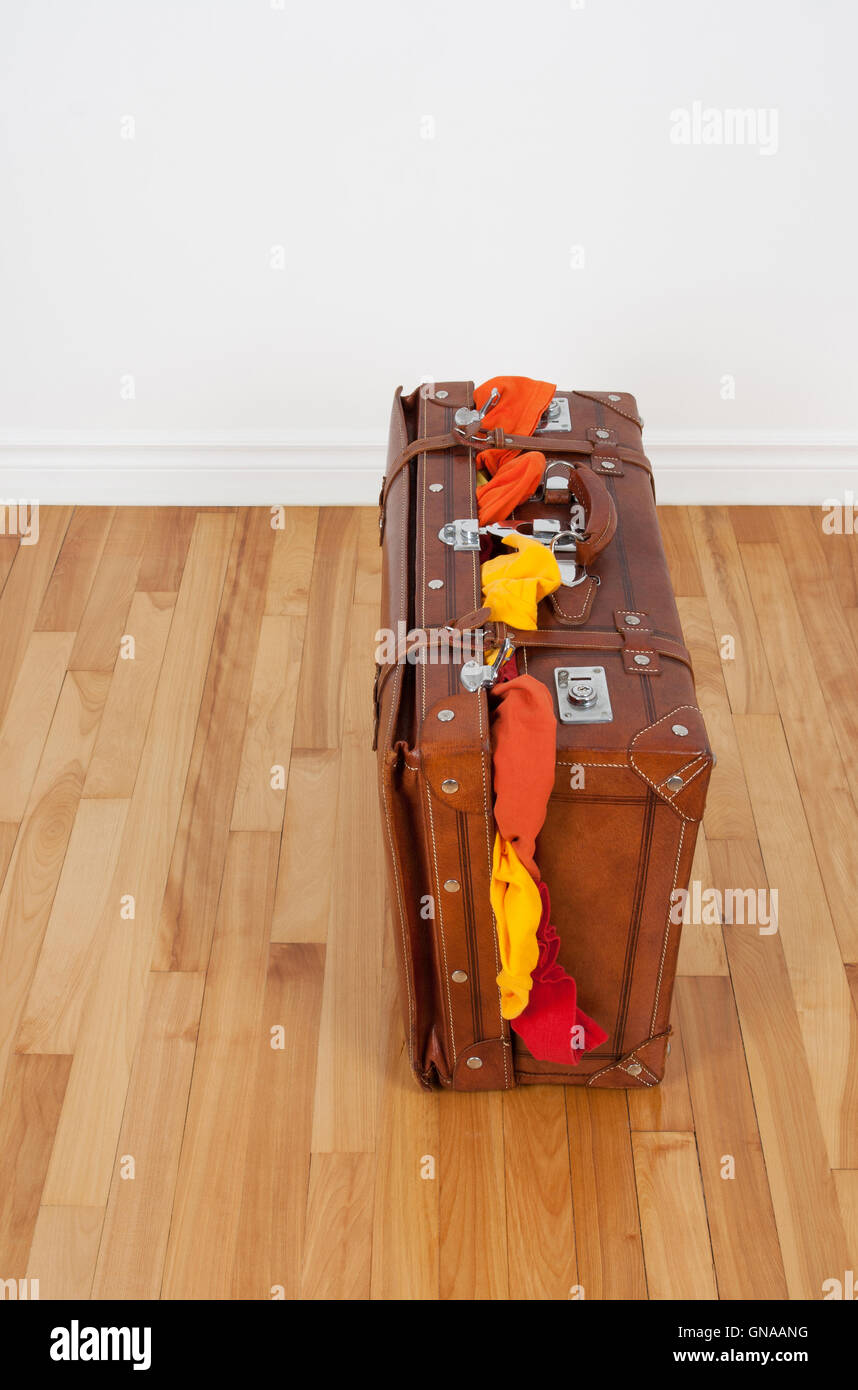 Leather suitcase with too much clothing Stock Photo - Alamy