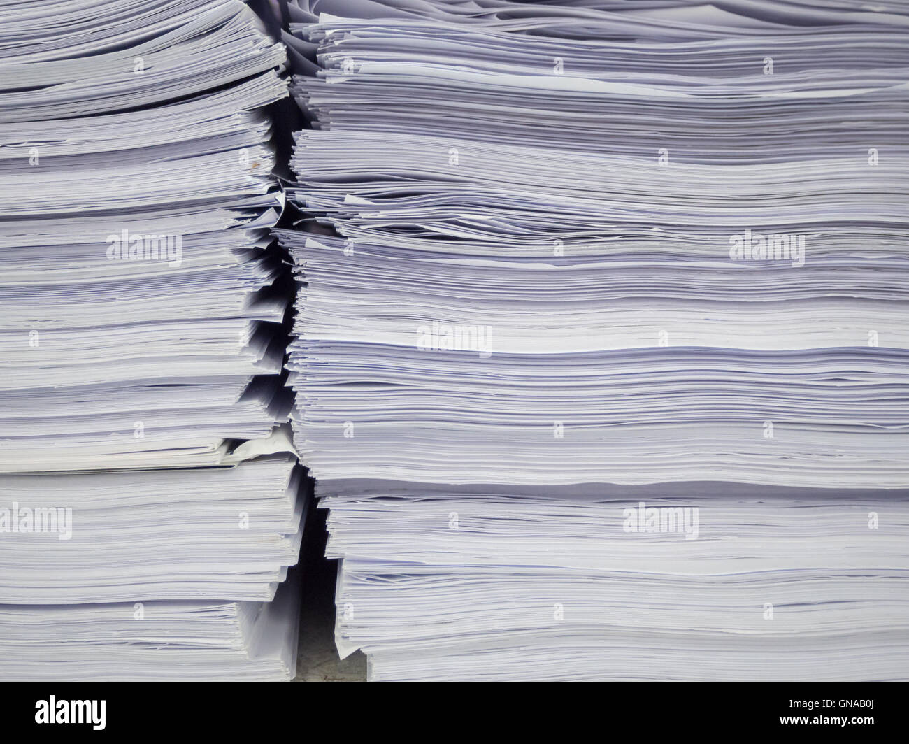 Pile of unfinished documents on office desk with businessman background ...