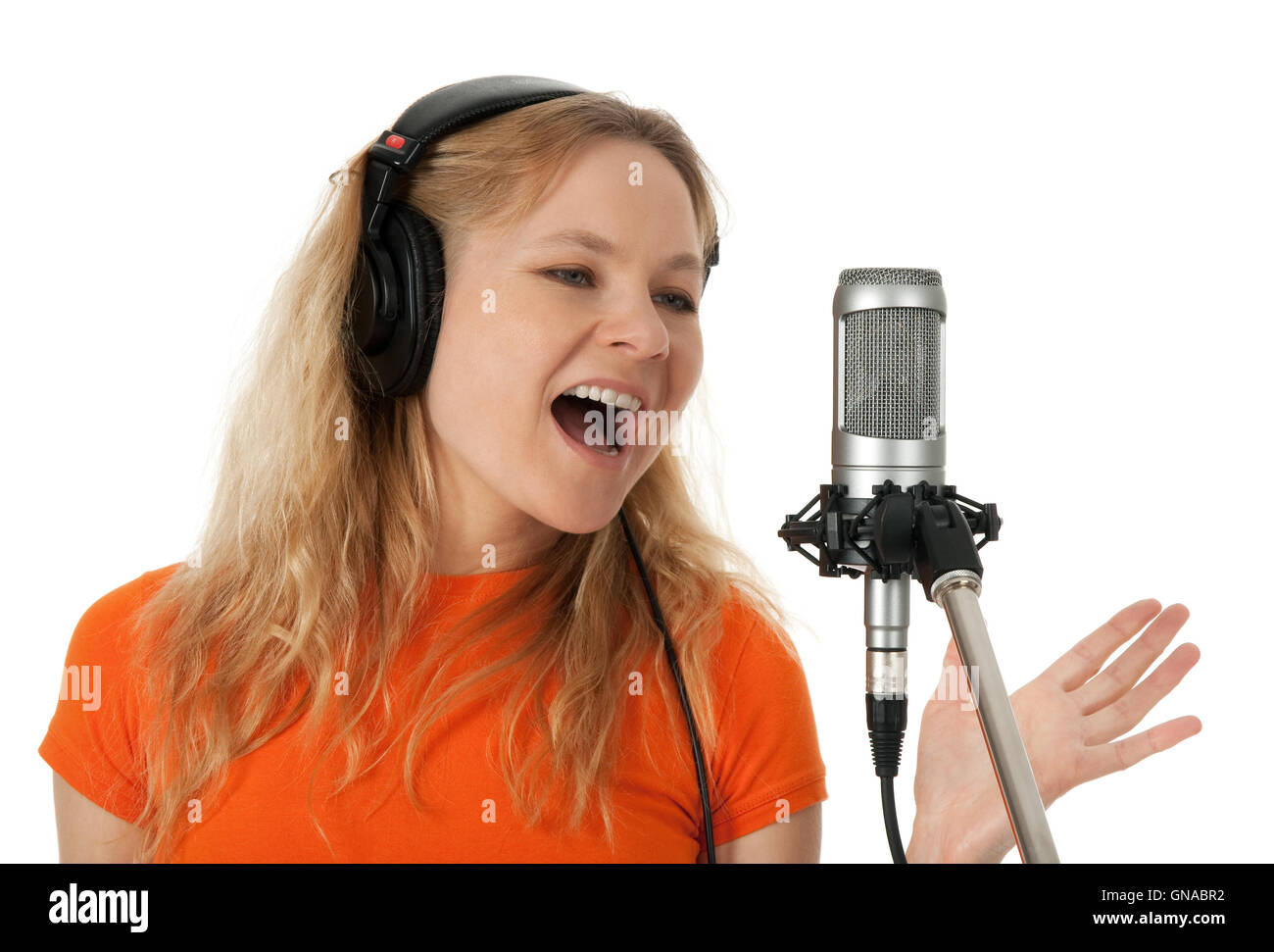 Singer in headphones singing with the microphone Stock Photo - Alamy