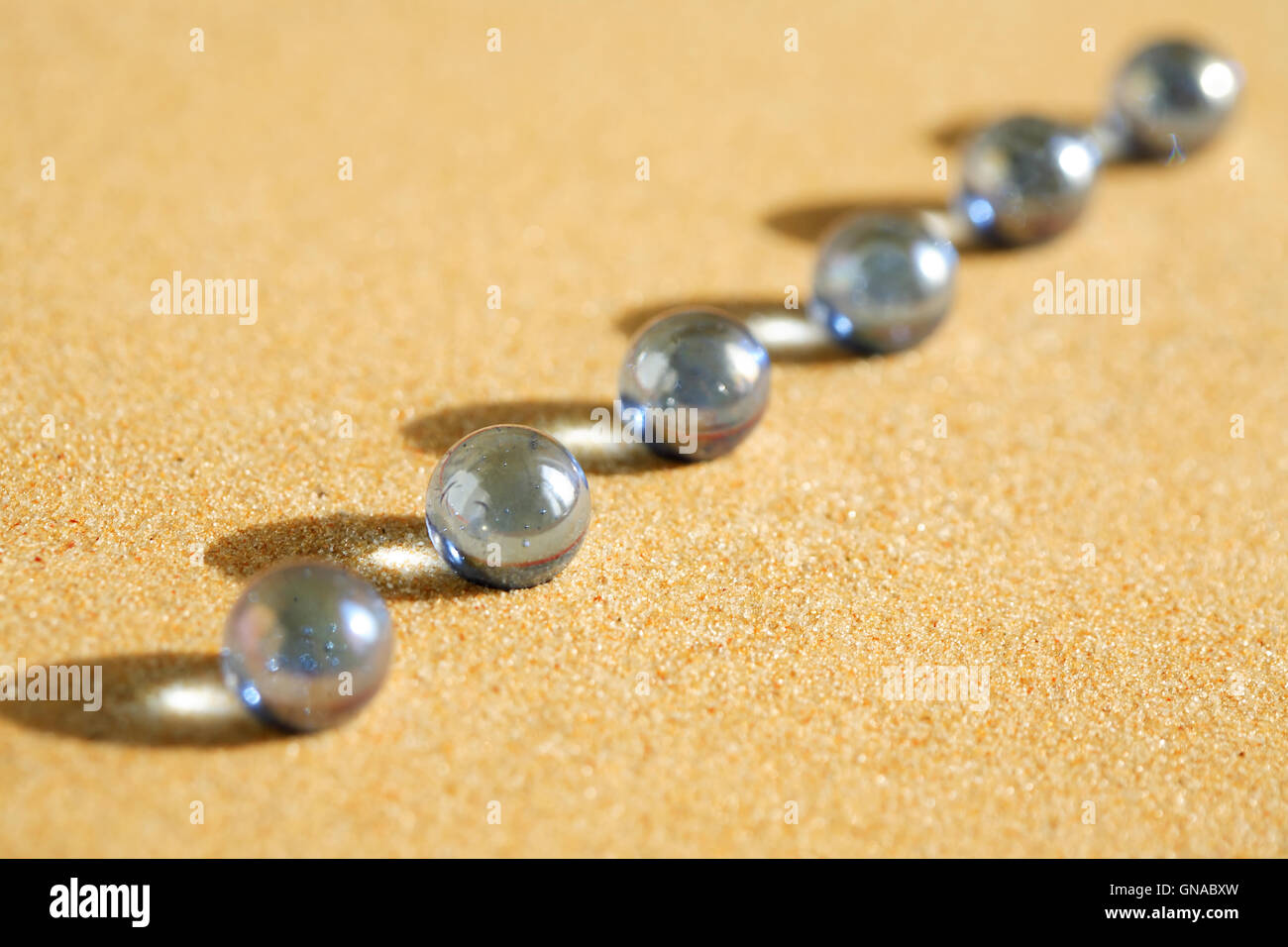 Glass Balls On Sand Stock Photo - Alamy