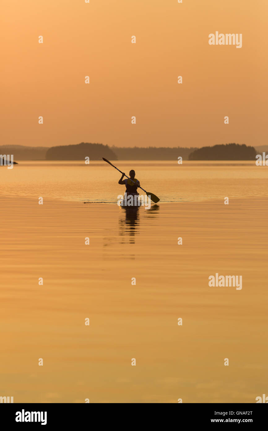 Paddle-boarding on lake during sunset Stock Photo - Alamy