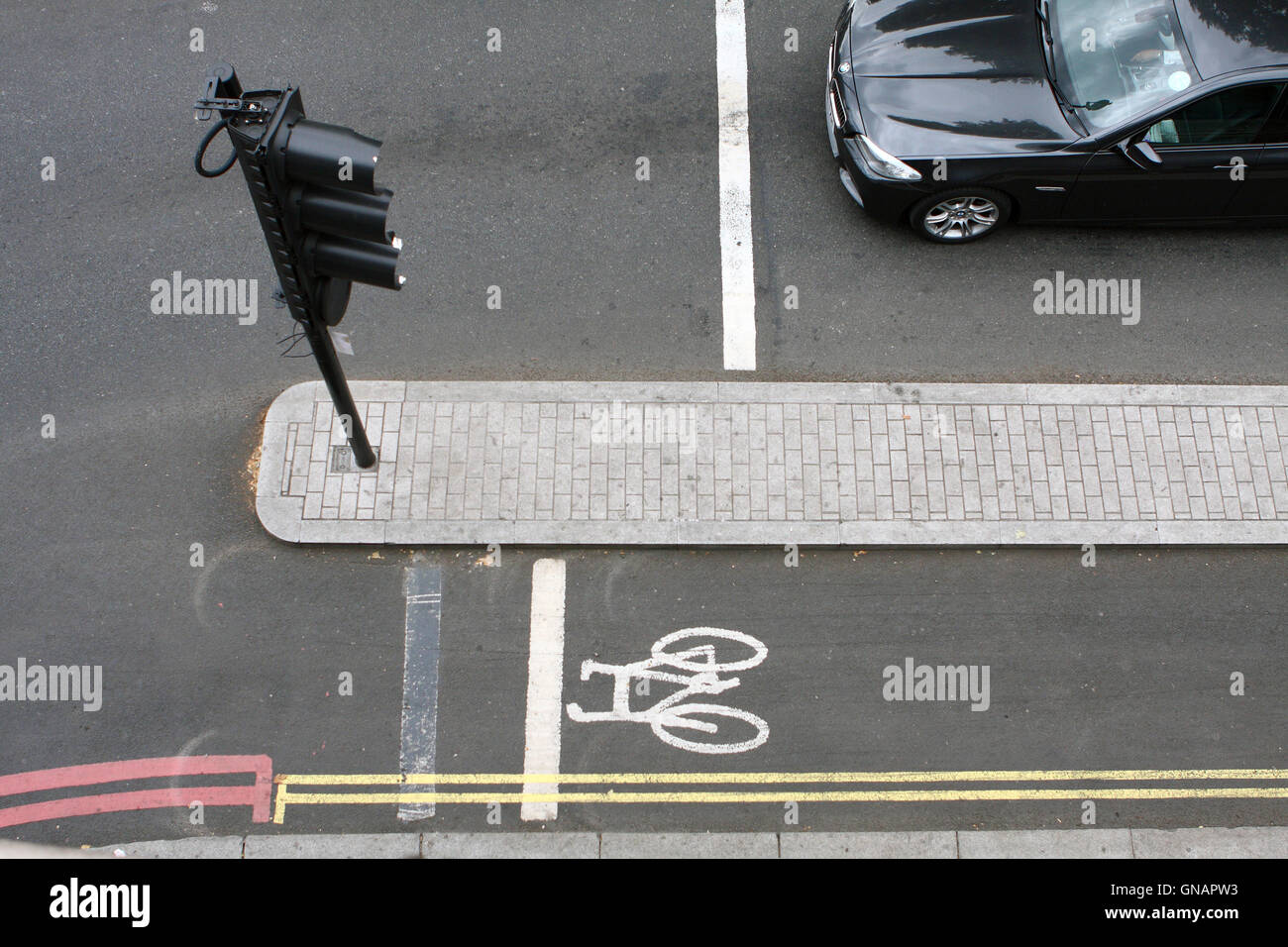 A vehicle waiting at a set of traffic lights next to an empty cycle ...