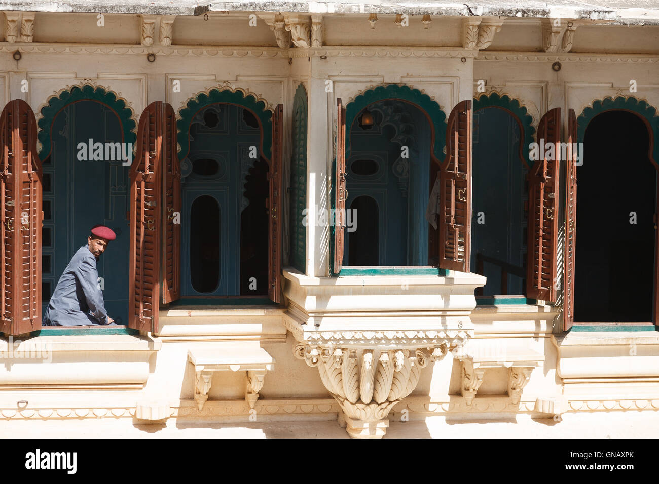 A security guard sitting a in a window in the City Palace, Udaipur ...