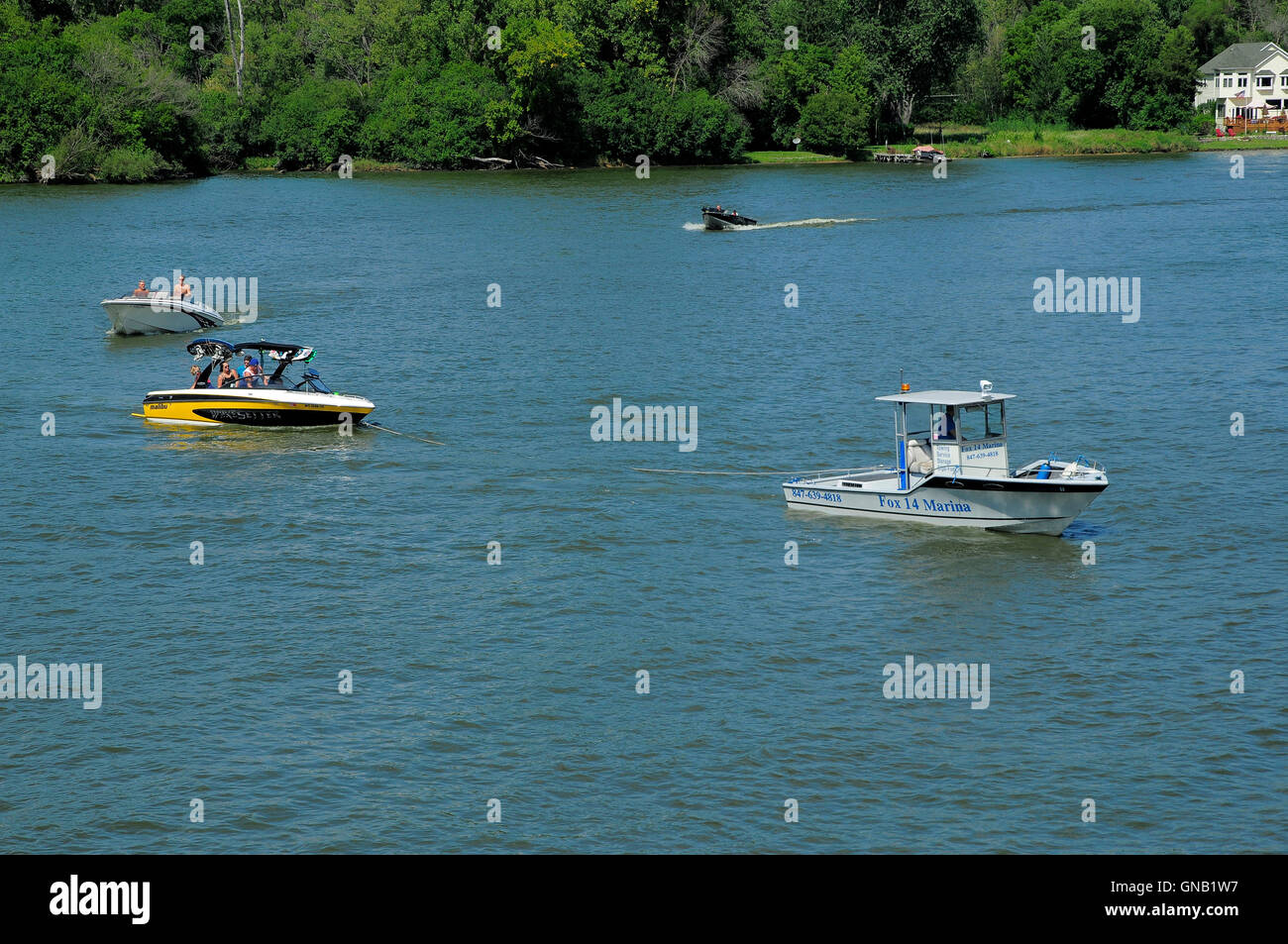 Recreational boating. Tow boat pulling broken down boat to shore Stock ...