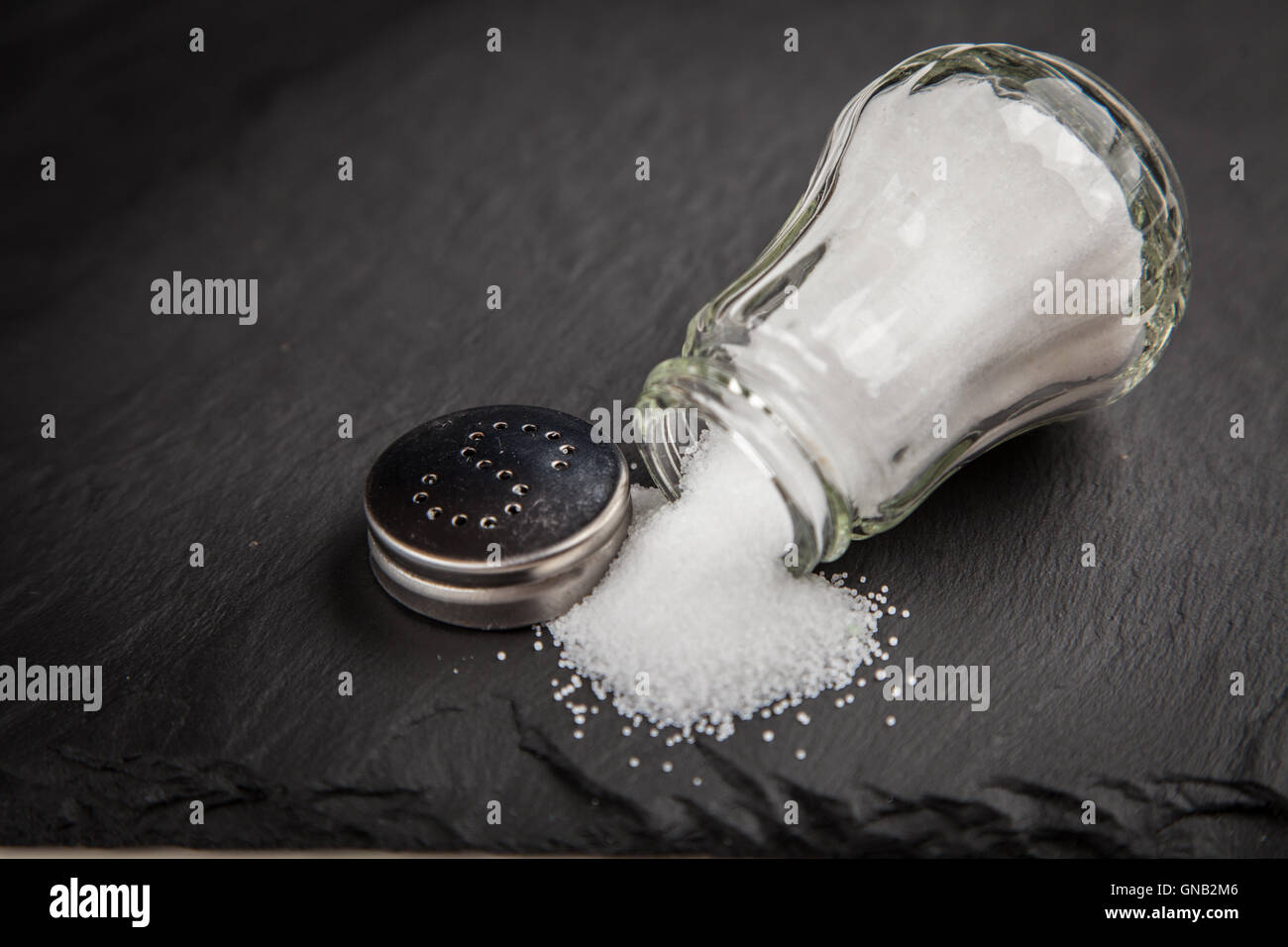 Salt shaker on slate board Stock Photo - Alamy
