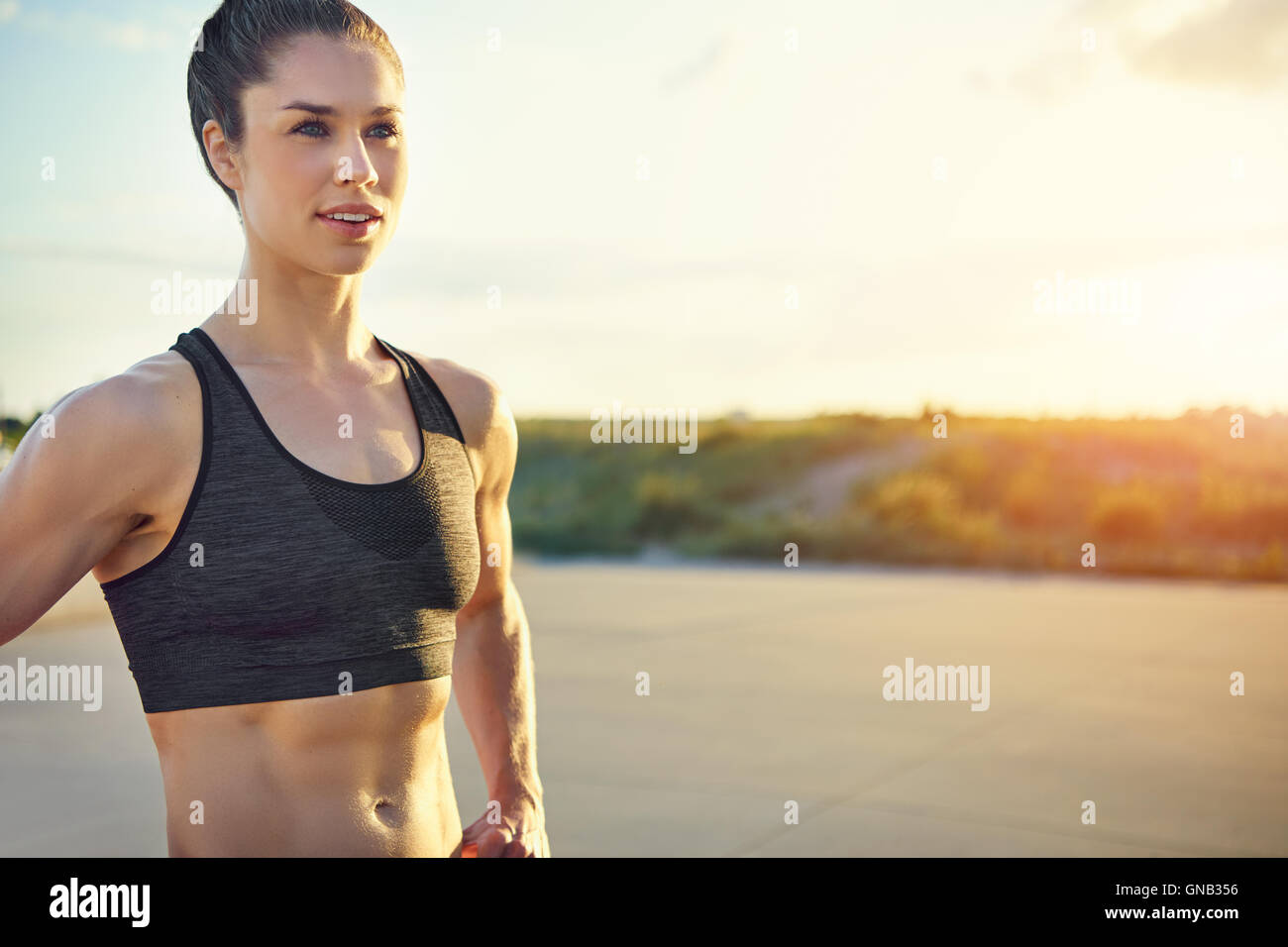 Attractive fit healthy young woman with a toned muscular body standing ...