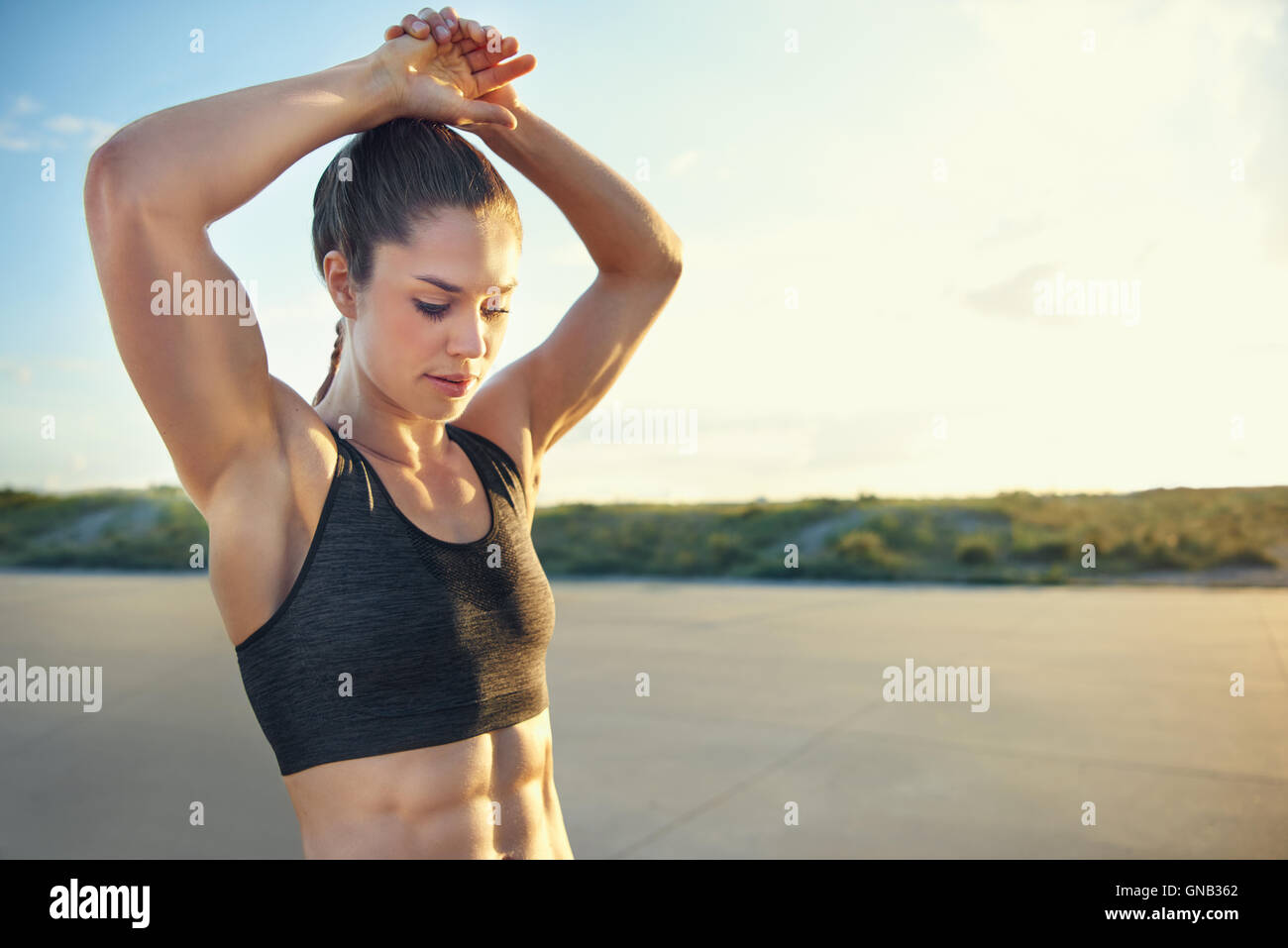 Fit young woman with toned abdominal muscles doing warming up exercises ...
