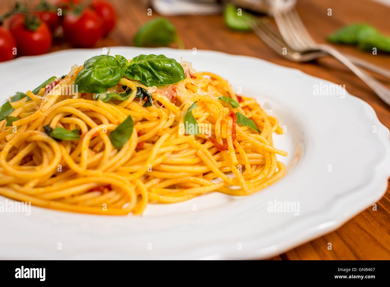 Traditional italian cuisine spaghetti with tomato sauce, basil and cheese on wood table Stock ...