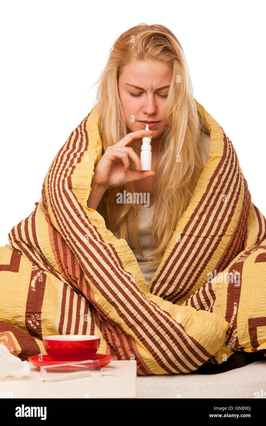 Sick woman sitting on bad wrapped in a blanket feeling ill, has flu and ...