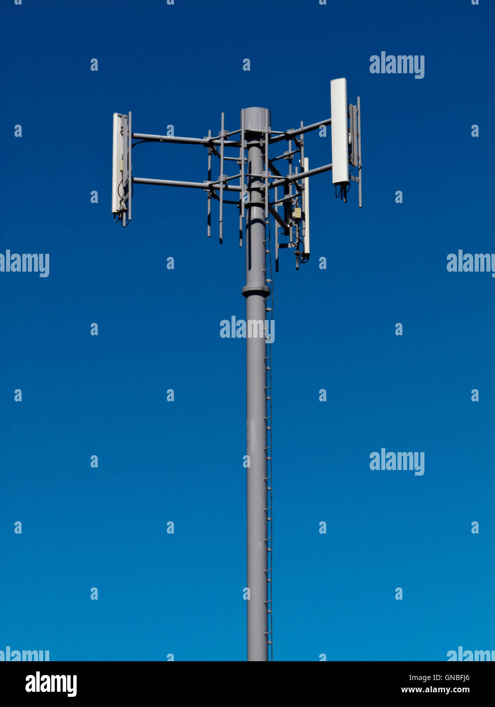 Mobile phone antennas on metal tower on blue sky Stock Photo - Alamy