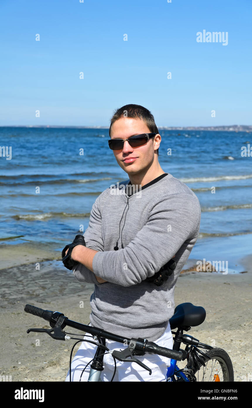 Portrait of handsome male with bicycle by the sea Stock Photo - Alamy