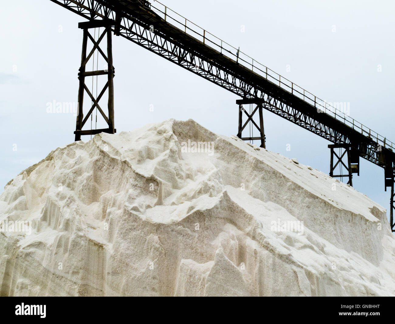 Pile of sea salt under conveyor of saline refinery Stock Photo - Alamy