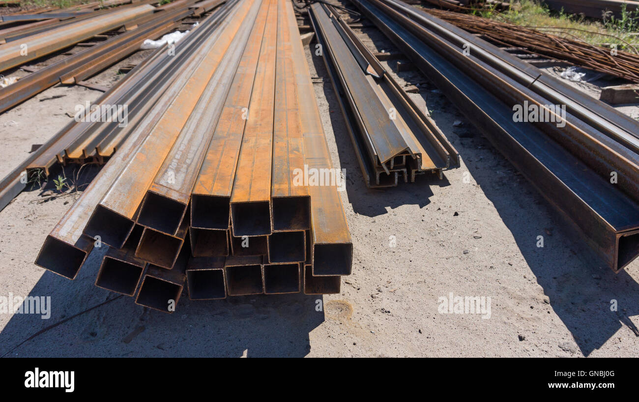 Metal rolling. Long steel square tubes folded on the ground Stock Photo ...