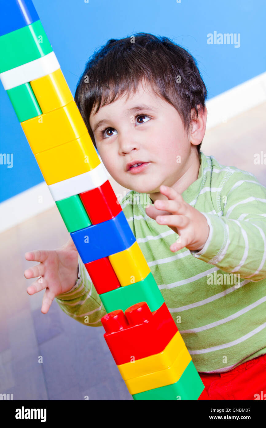Funny little boy playing with plastic colorful blocks, studio sh Stock ...