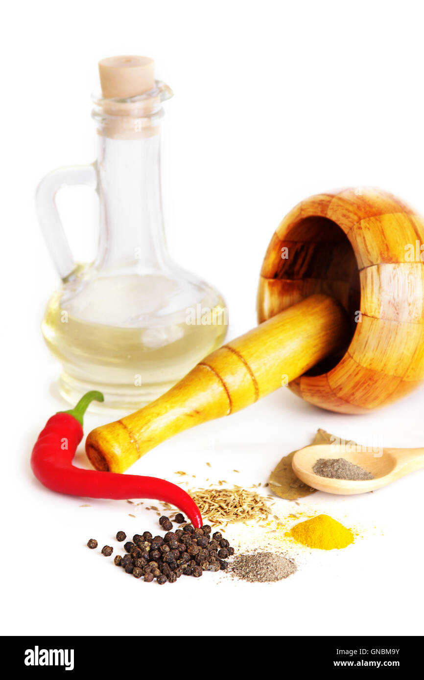 Mortar with pestle, variety of spices and oil Stock Photo - Alamy