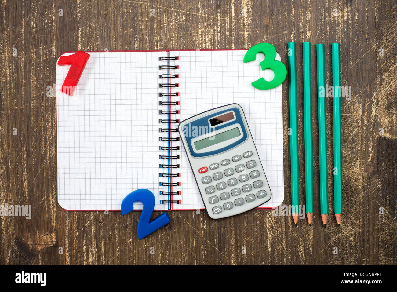 Digital calculator,open notebook,color numbers and pencil.Top view ...