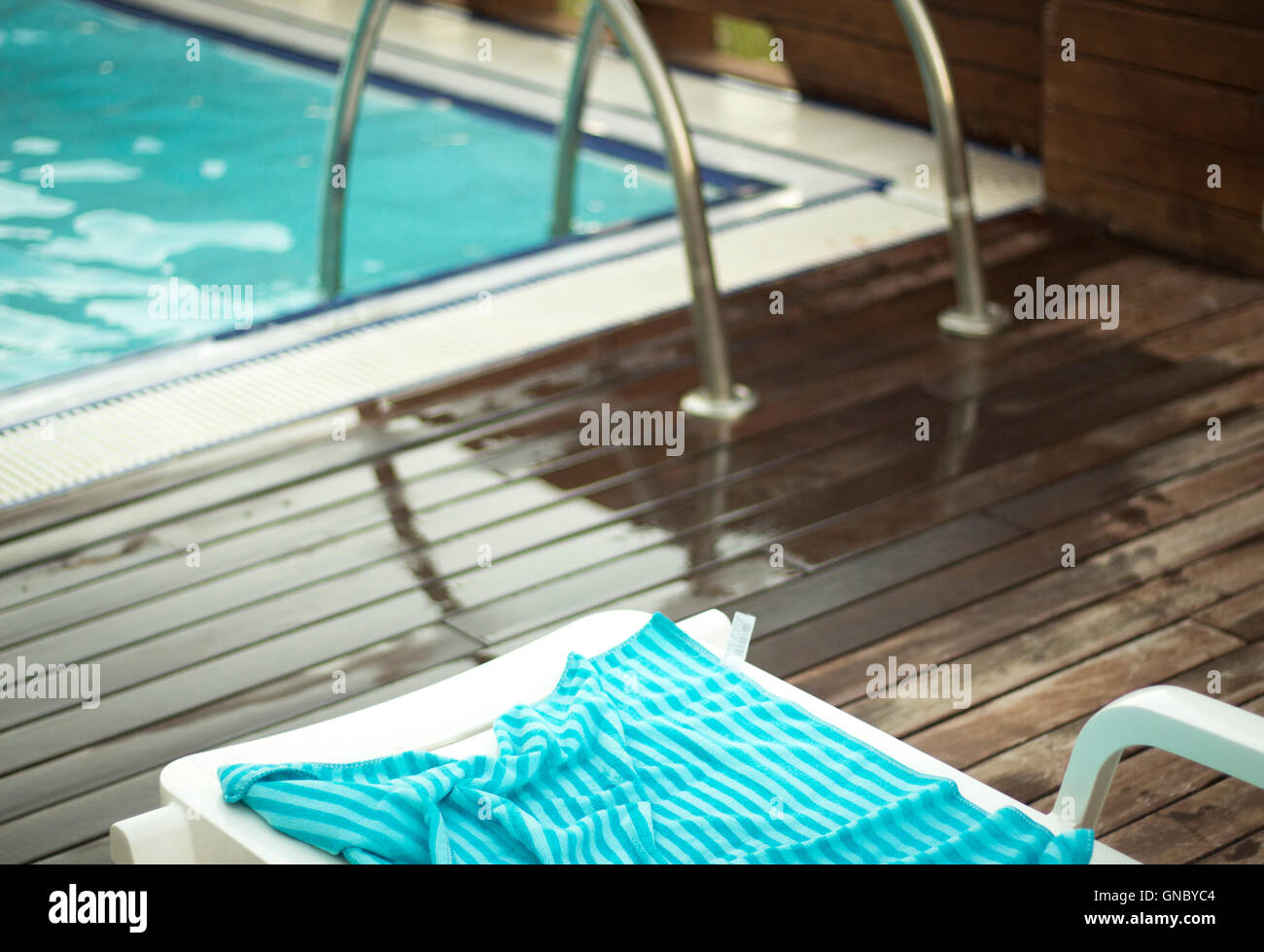 Hot summer by the outdoors swimming pool with wooden sundeck terrace ...
