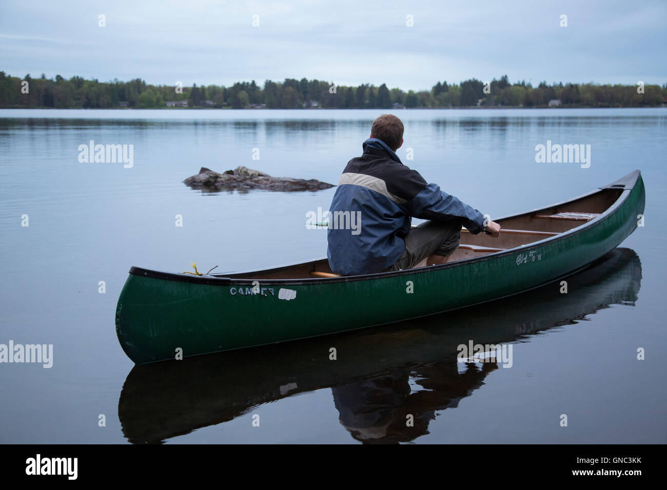 Man sitting in canoe in still lake hi-res stock photography and images ...