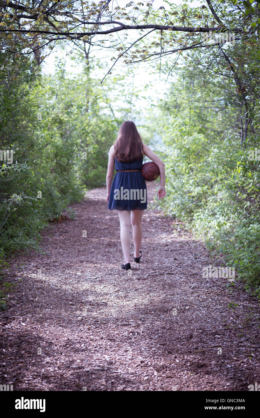Teenage Girl Walking with Basketball, Rear View Stock Photo - Alamy