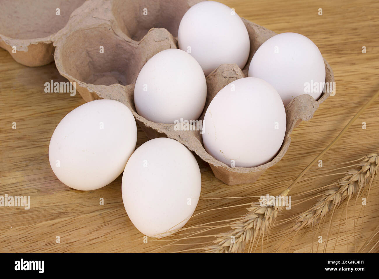 Group of fresh white eggs isolated in carton on rustic table, natural ...