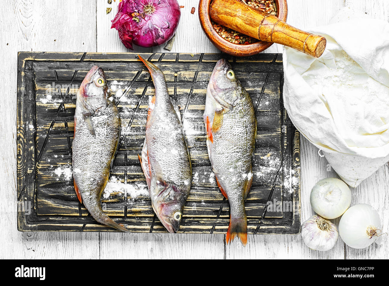 Three fish on kitchen cutting board,spice,onion and flour Stock Photo ...