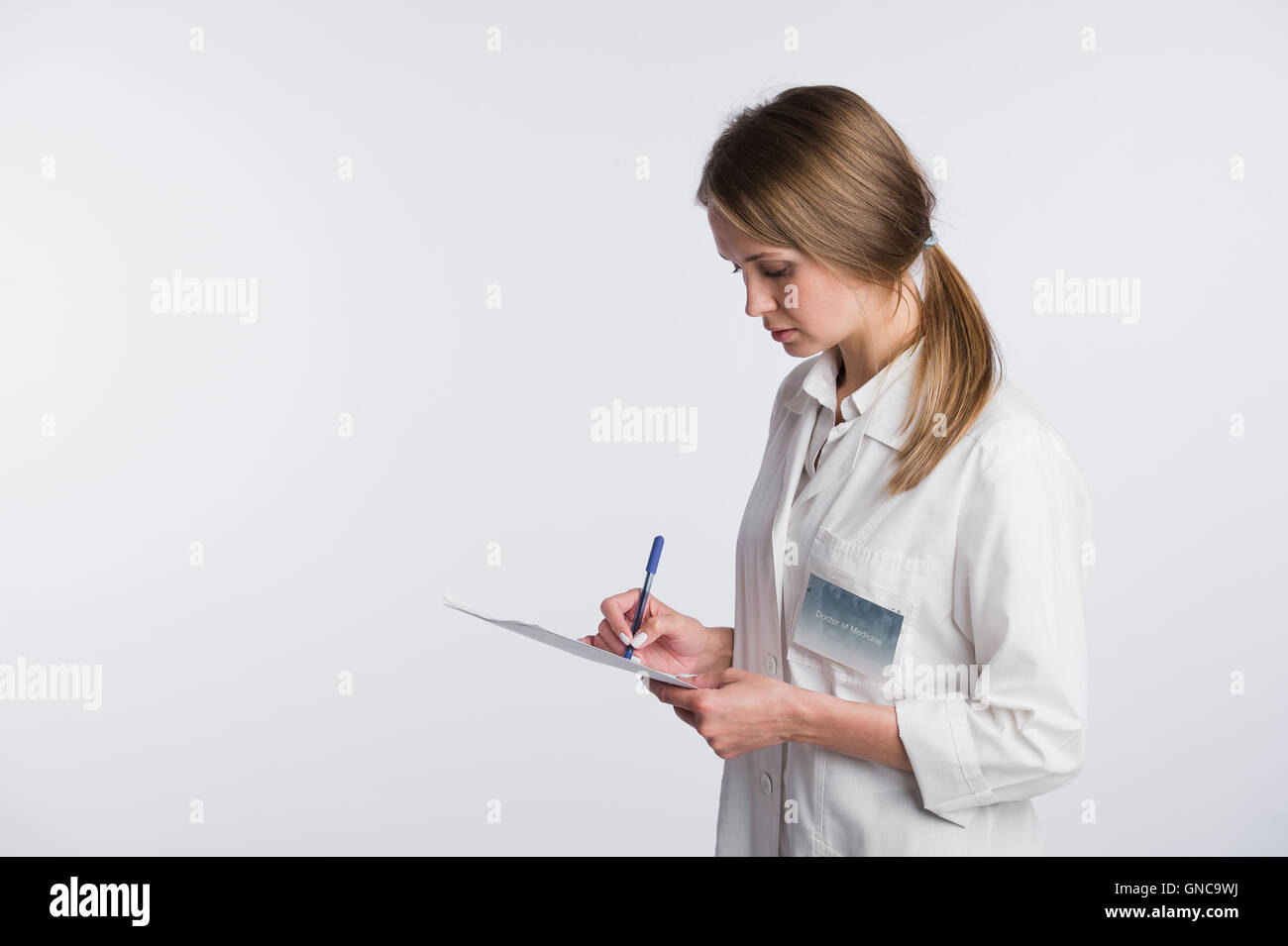 Cheerful medical doctor woman taking notes. Isolated on white Stock ...