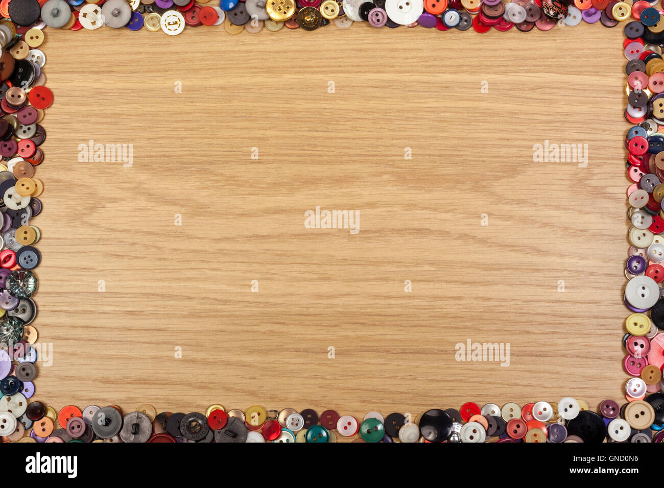 Wooden grained background with a colorful assortment of buttons forfing ...