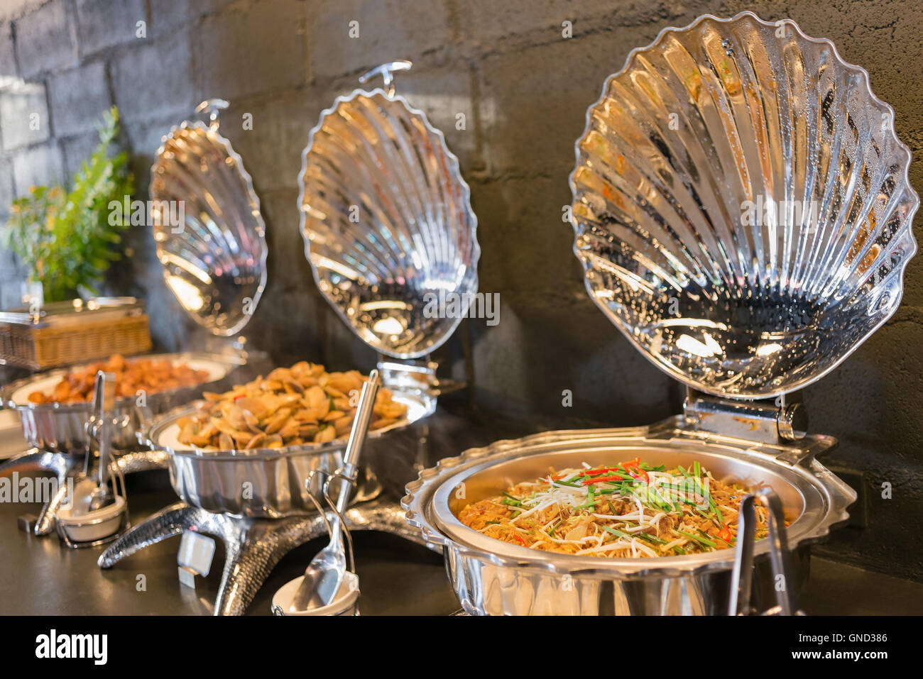 Buffet line food containers shaped shells, with dark bricks wall ...