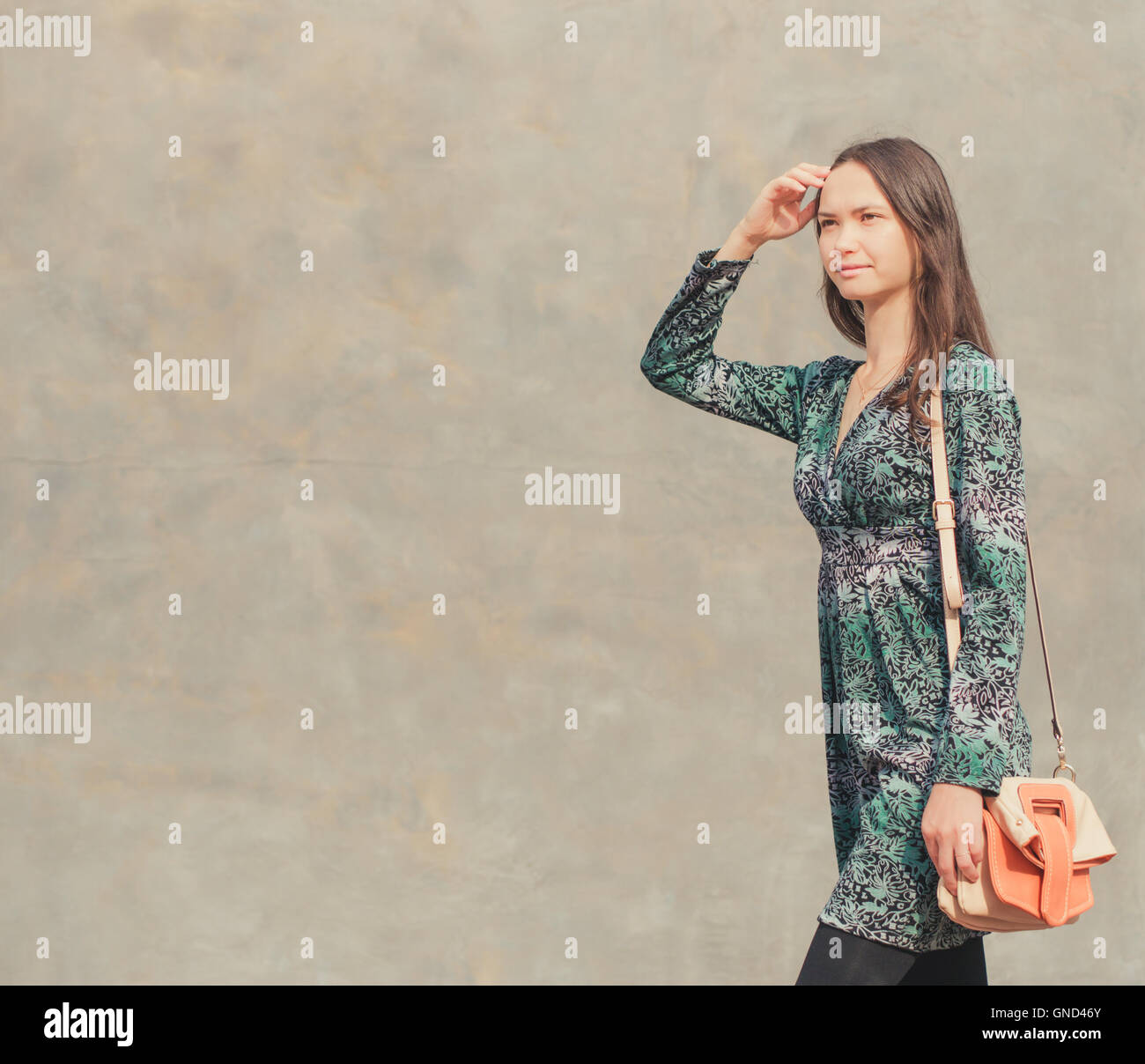 woman walking on street in front of gray wall Stock Photo - Alamy