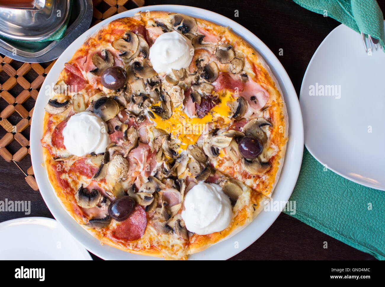 Round pizza served on a plate at the restaurant Stock Photo - Alamy