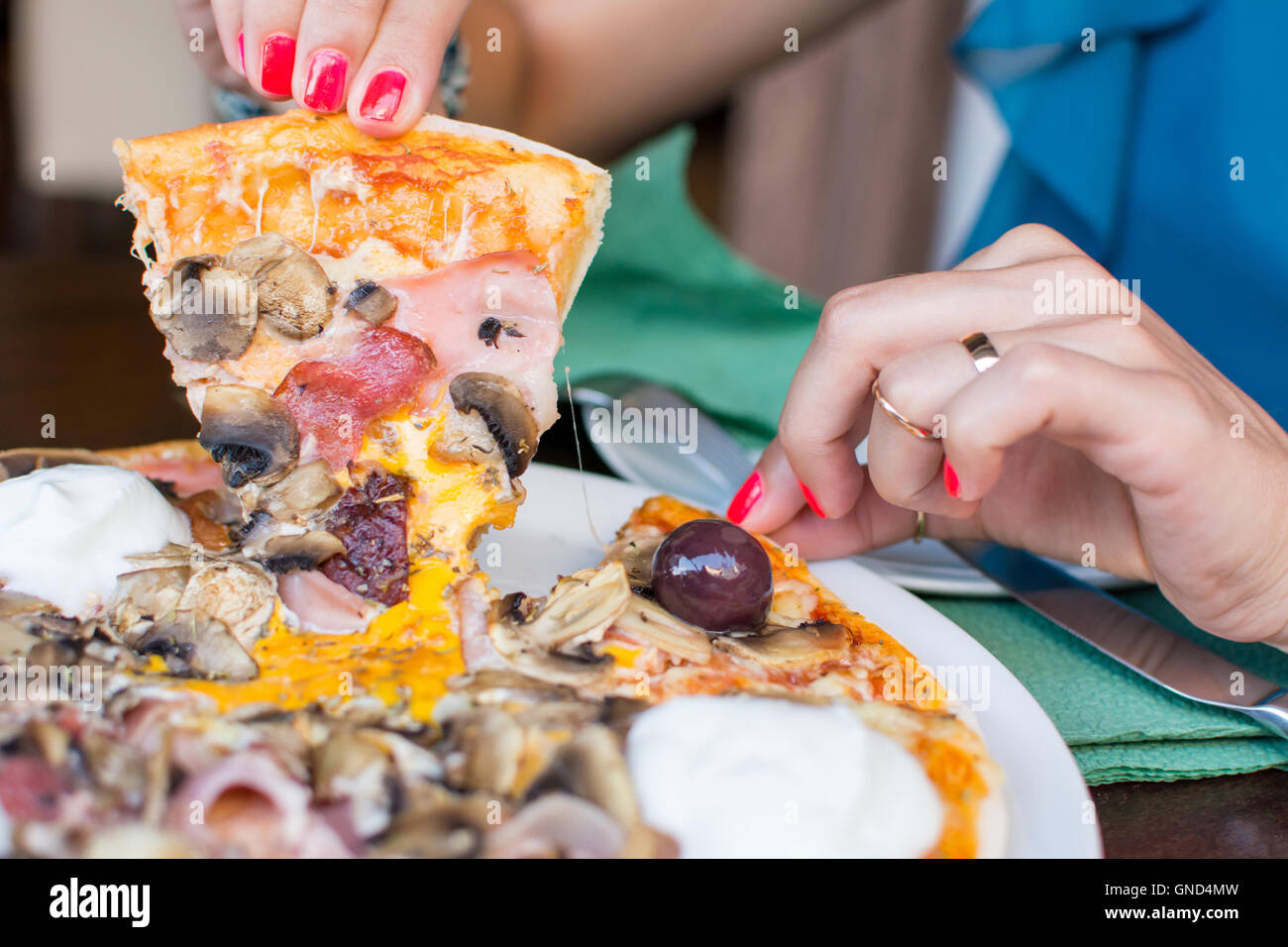 Woman hands while eating pizza at the restaurant Stock Photo - Alamy