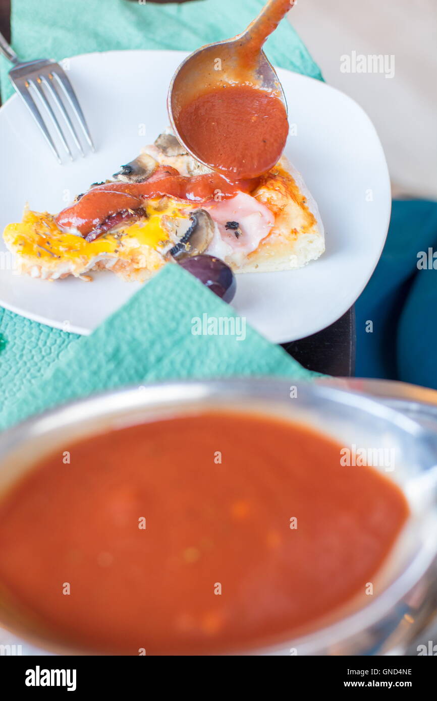 putting ketchup on pizza slice at the restaurant Stock Photo - Alamy