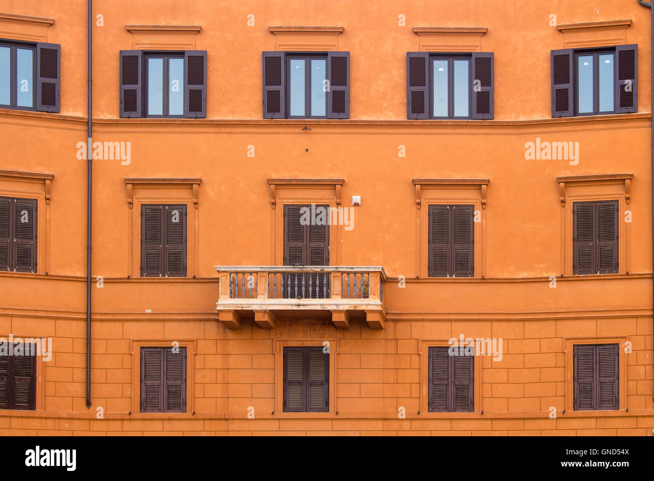 Typical orange color of the facade of a house in Rome. Windows ...