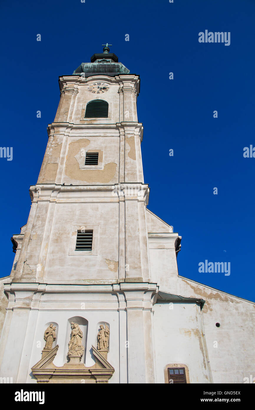 Church of Saint Cross. Old facade, high tower with clock. Cross on the ...