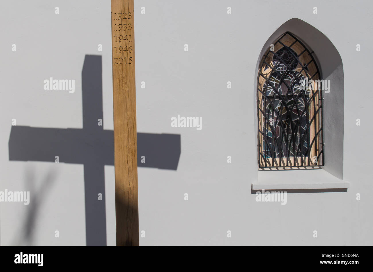 Wooden cross with a years of Saint Missions and its shadow on the wall ...