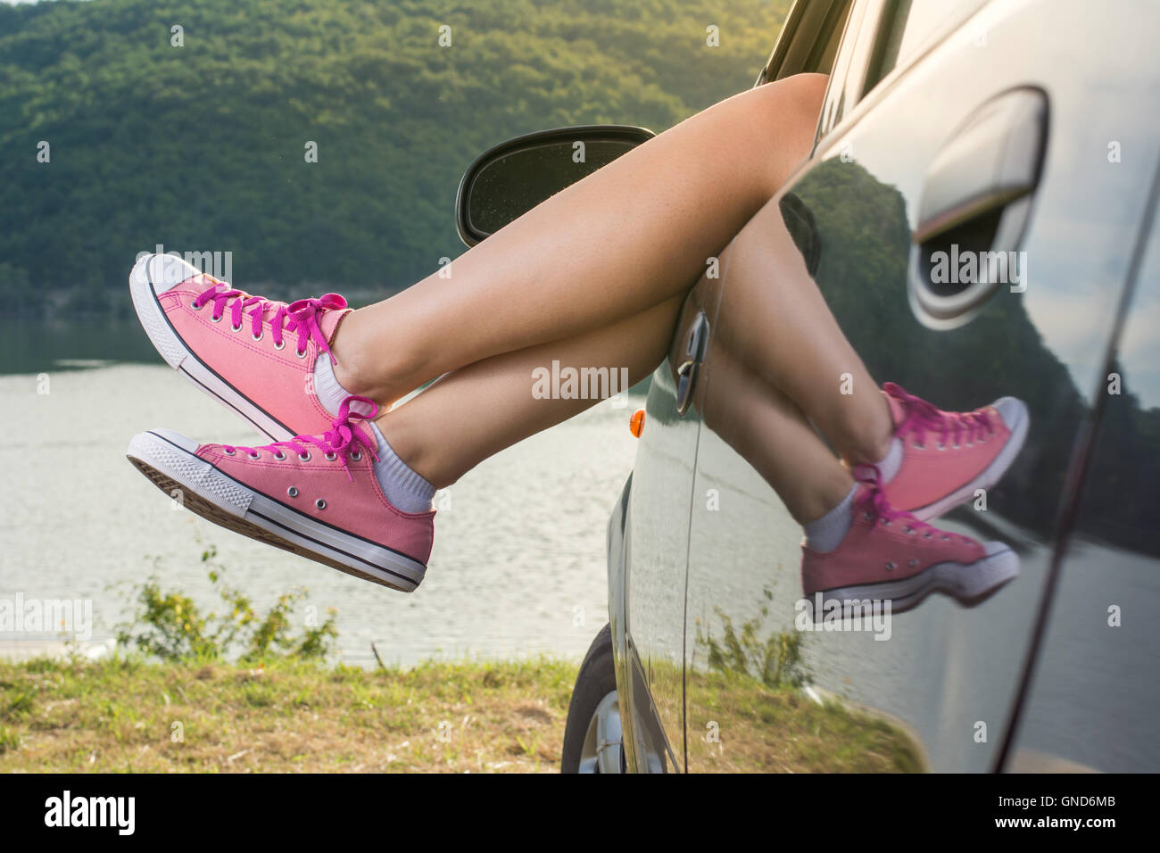 Woman legs out of the car window by the lake Stock Photo - Alamy