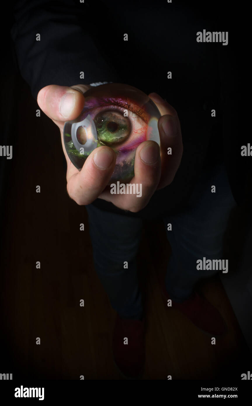 Holding third eye in fortune teller magic crystal ball Stock Photo - Alamy