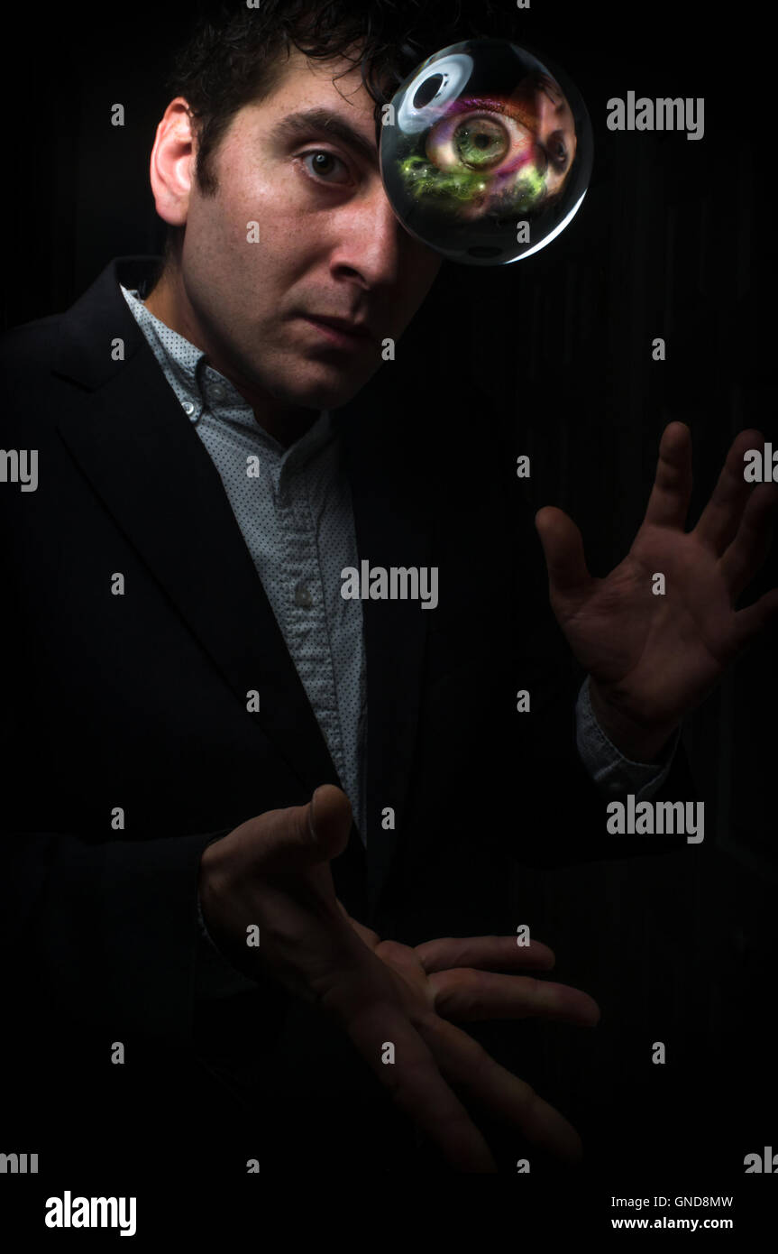 Holding third eye in fortune teller magic crystal ball Stock Photo - Alamy
