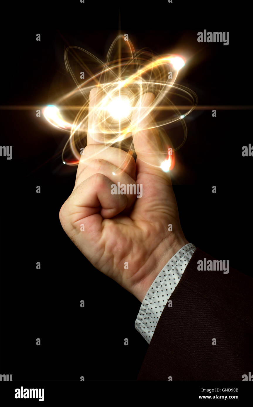 Scientist man holding atom particle between his fingers Stock Photo - Alamy