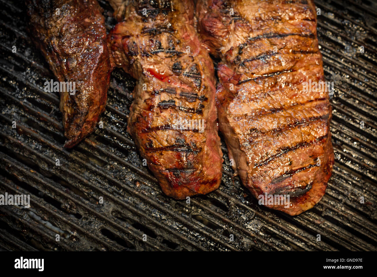 Grilling large juicy beef steaks for summer barbecue Stock Photo - Alamy