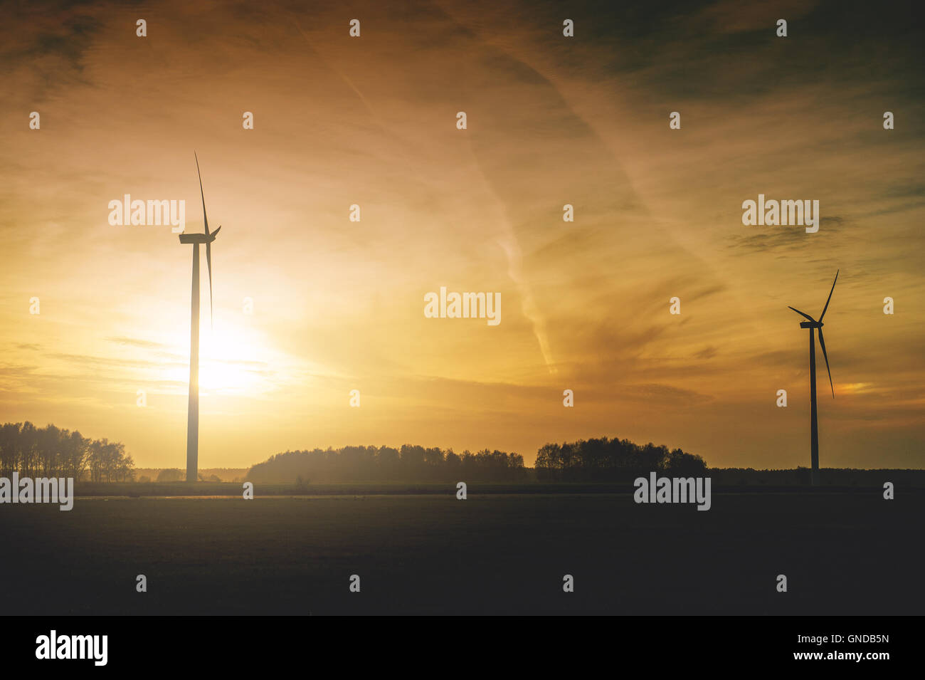 Wind turbine farm with rays of light at sunset Stock Photo - Alamy