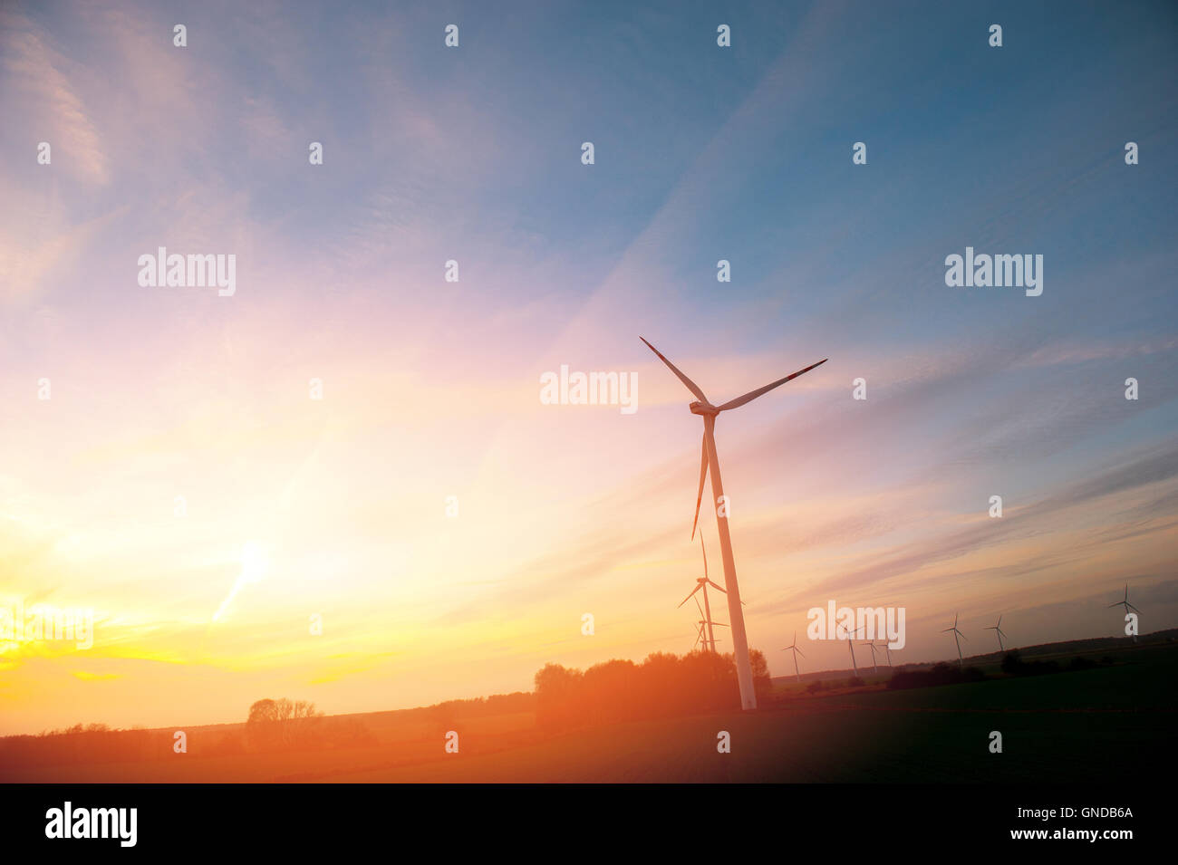 Wind turbine farm with rays of light at sunset Stock Photo - Alamy