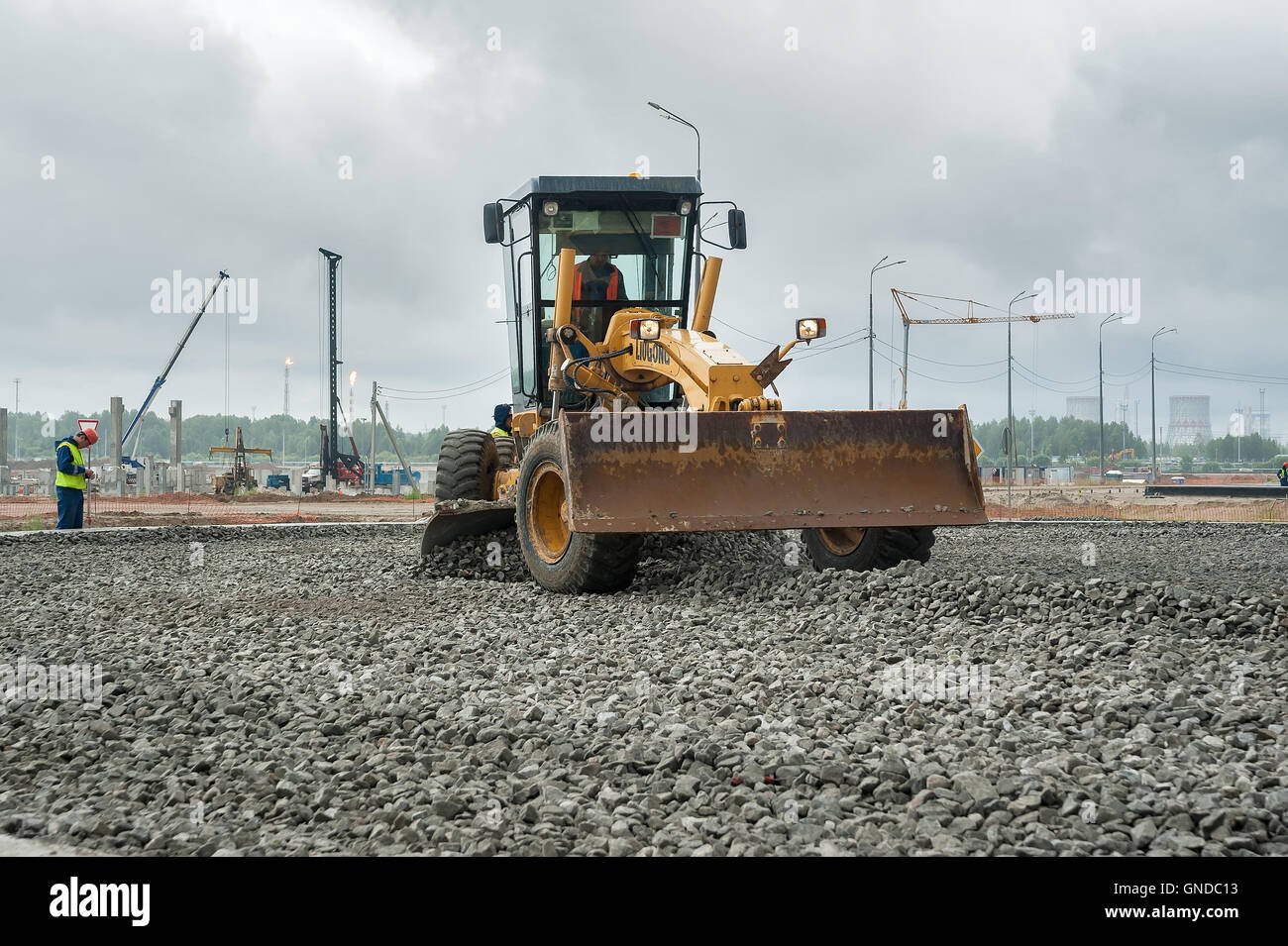 Grader leveling gravel on construction site Stock Photo - Alamy