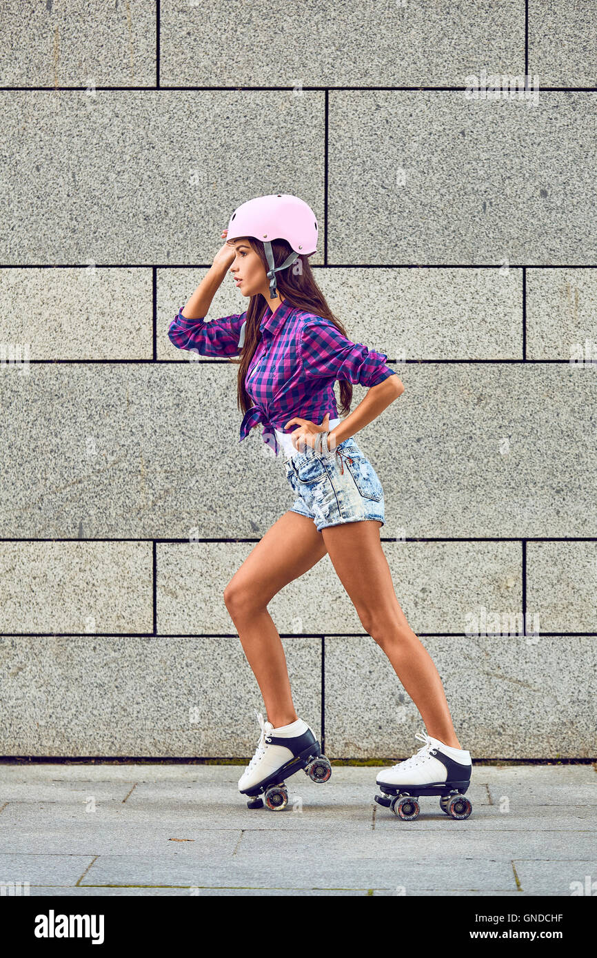 Full length of happy young woman roller skating Stock Photo - Alamy