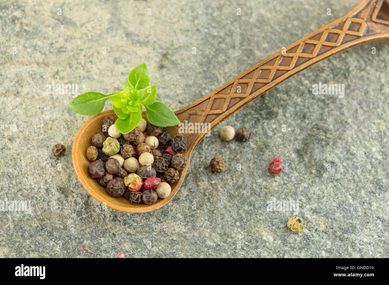 pepper spice grains in a wooden spoon on a stone table Stock Photo - Alamy