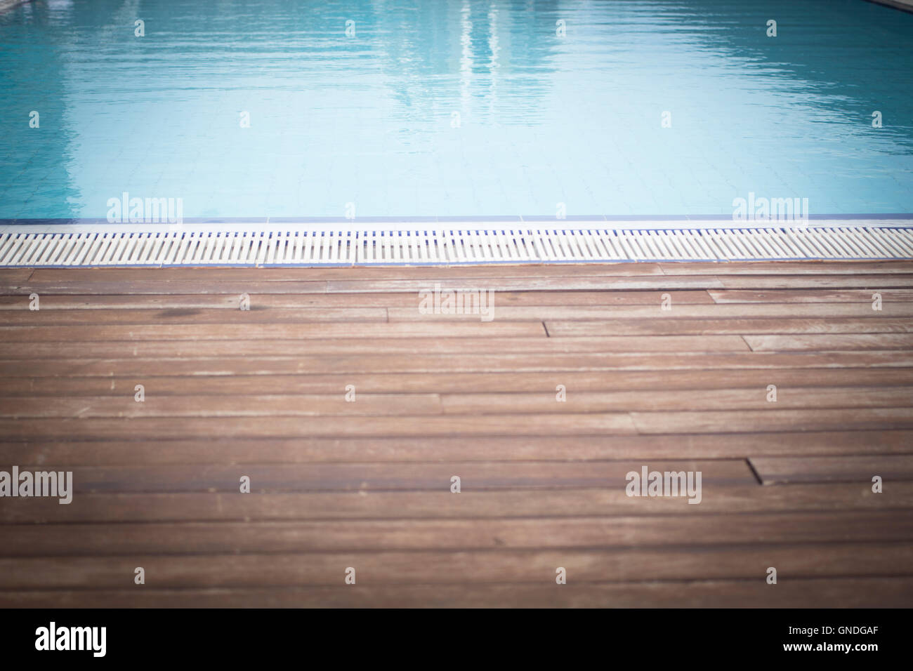 Hot summer by the outdoors swimming pool with wooden sundeck terrace ...