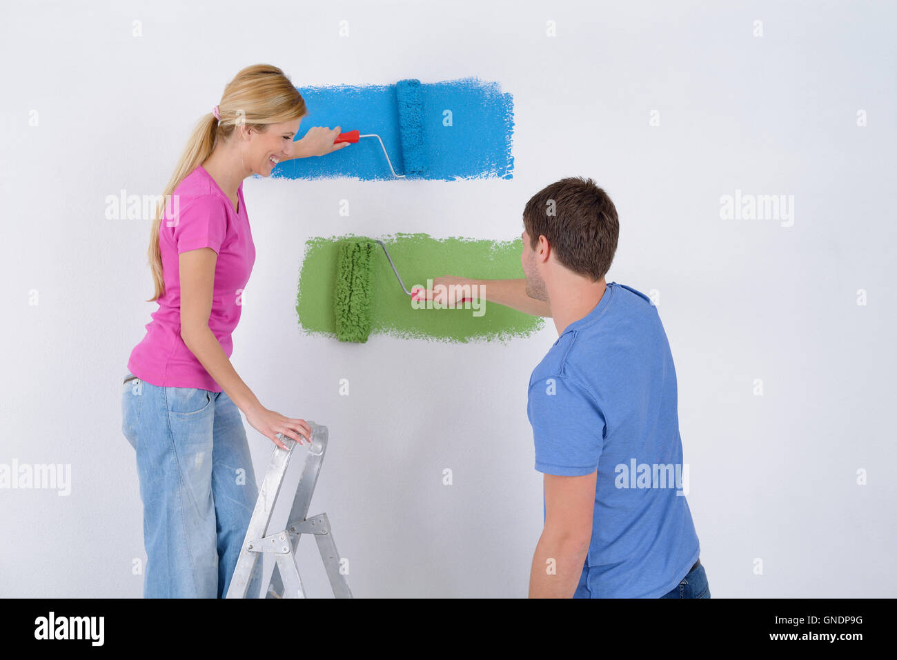happy couple paint wall at new home Stock Photo - Alamy