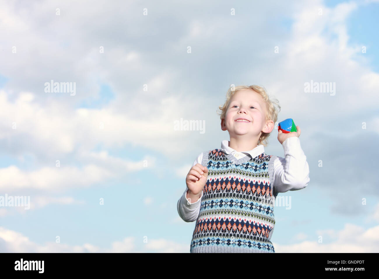 Happy little boy throwing a ball Stock Photo - Alamy
